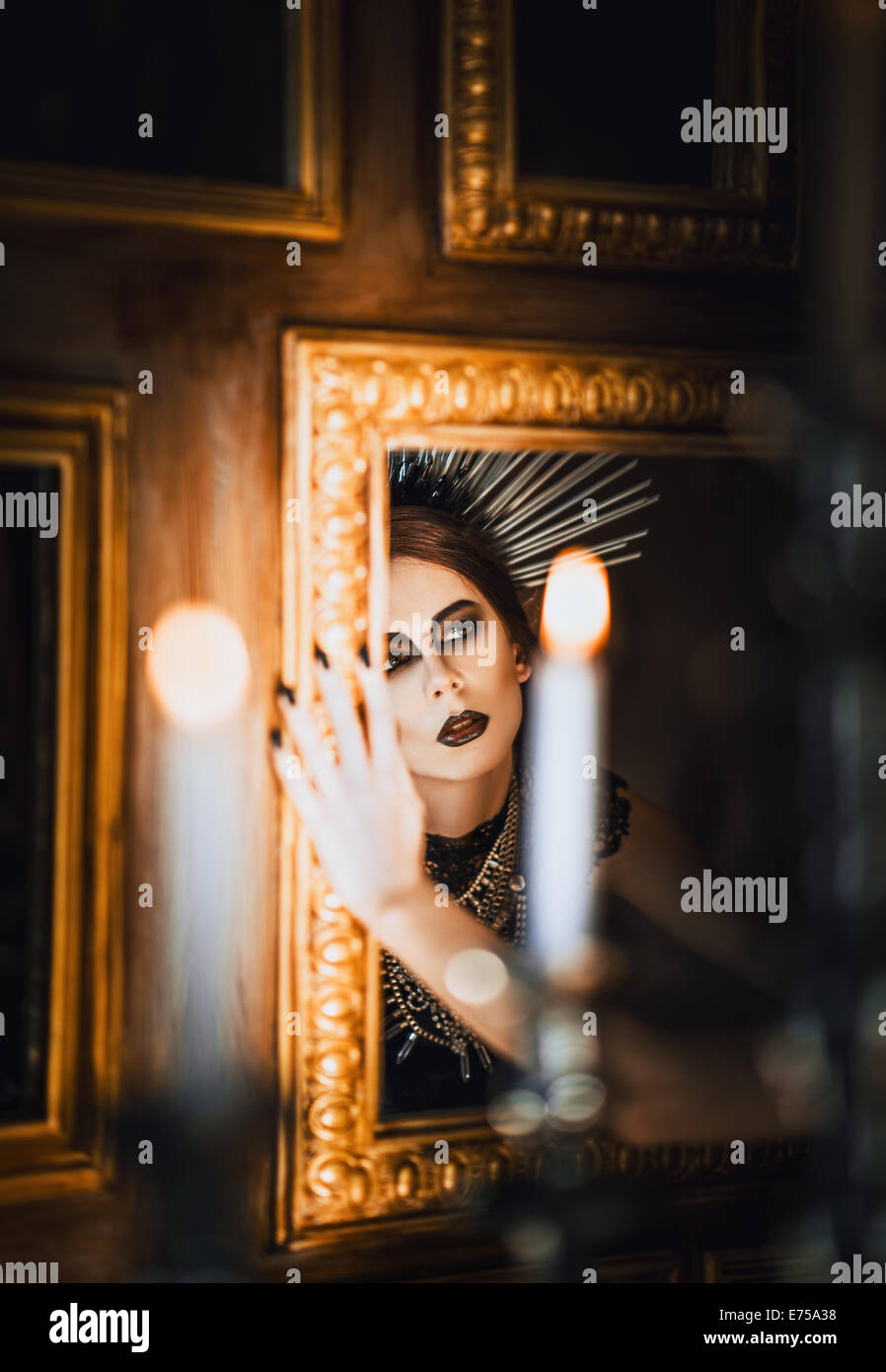 Mysterious portrait of beautiful goth girl looking into the mirror ...
