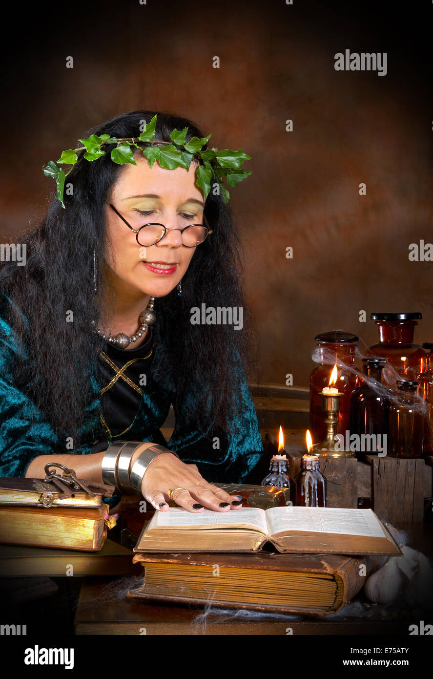 Halloween witch reading in her book of shadows Stock Photo - Alamy