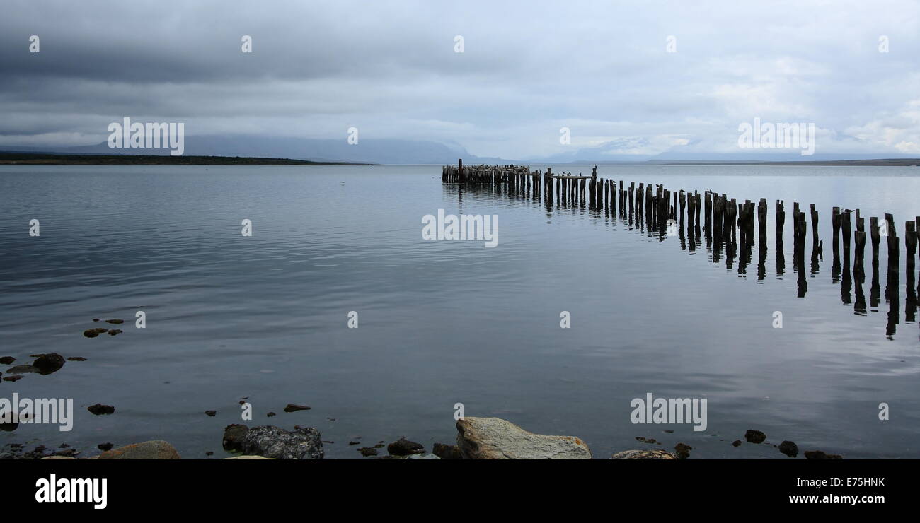 Wooden pier and a smooth, calm ocean viewed from Puerto Natales ...