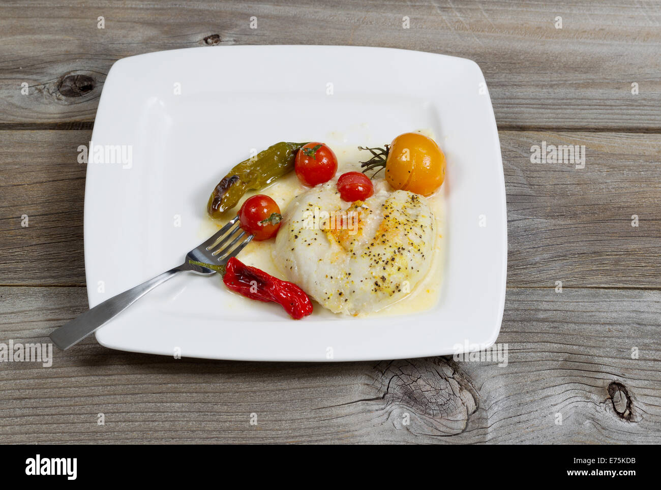 Closeup view of baked stuffed sole fish, tomatoes, green pepper in ...