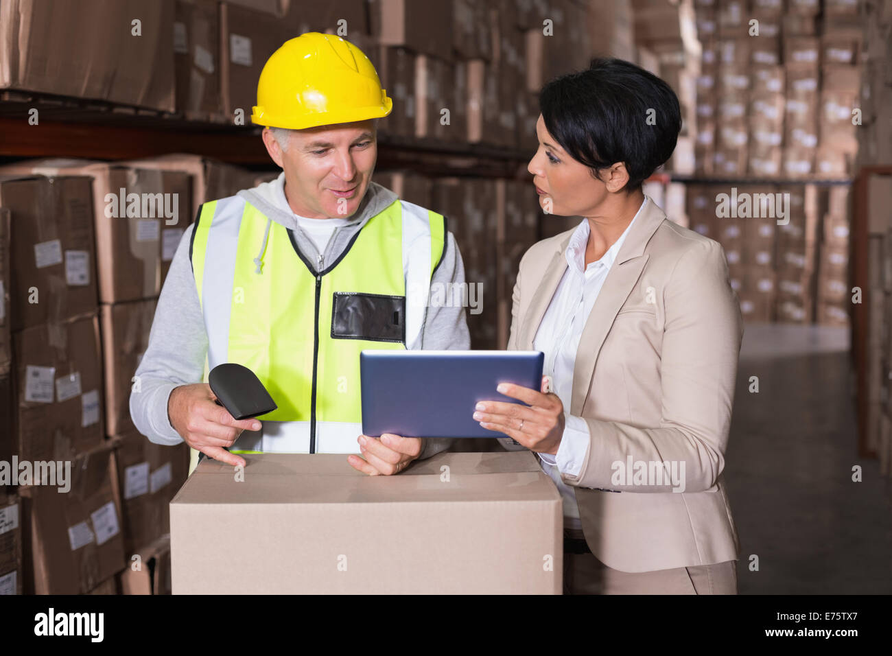 Warehouse worker scanning box with manager Stock Photo - Alamy