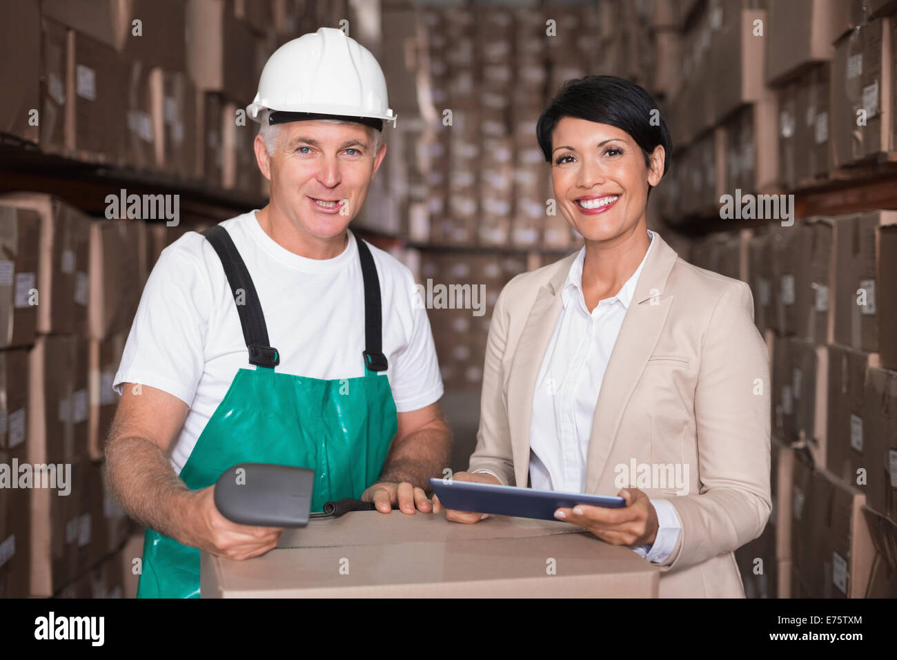 Warehouse worker scanning box with manager holding tablet pc Stock ...