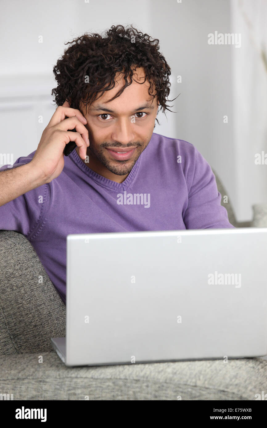 Man with computer talking on the phone Stock Photo - Alamy