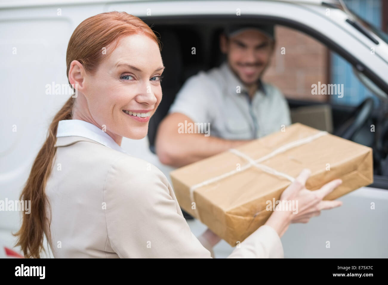 Delivery driver handing parcel to customer in his van Stock Photo - Alamy
