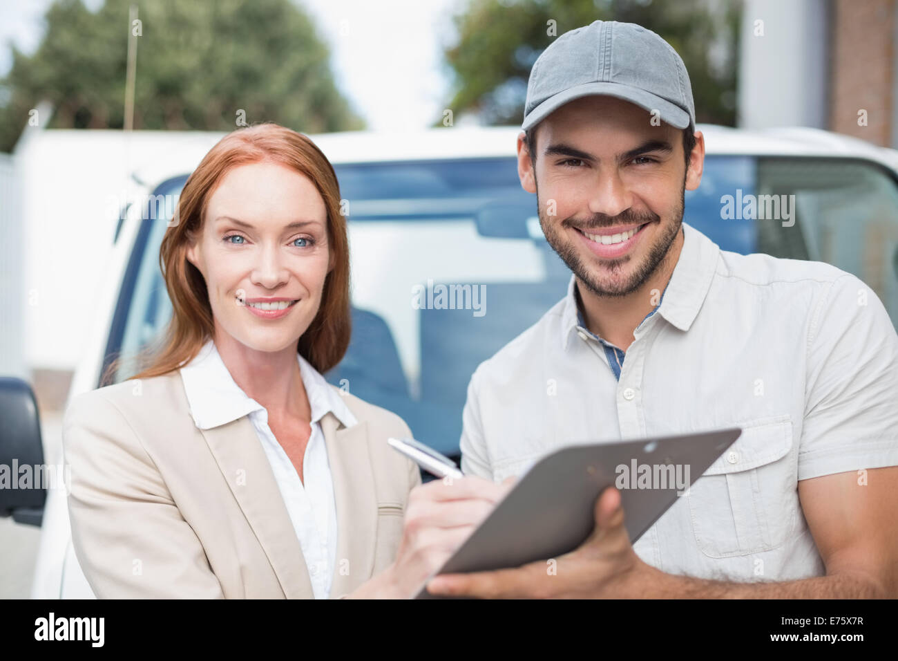 Delivery driver showing where to sign to customer Stock Photo - Alamy
