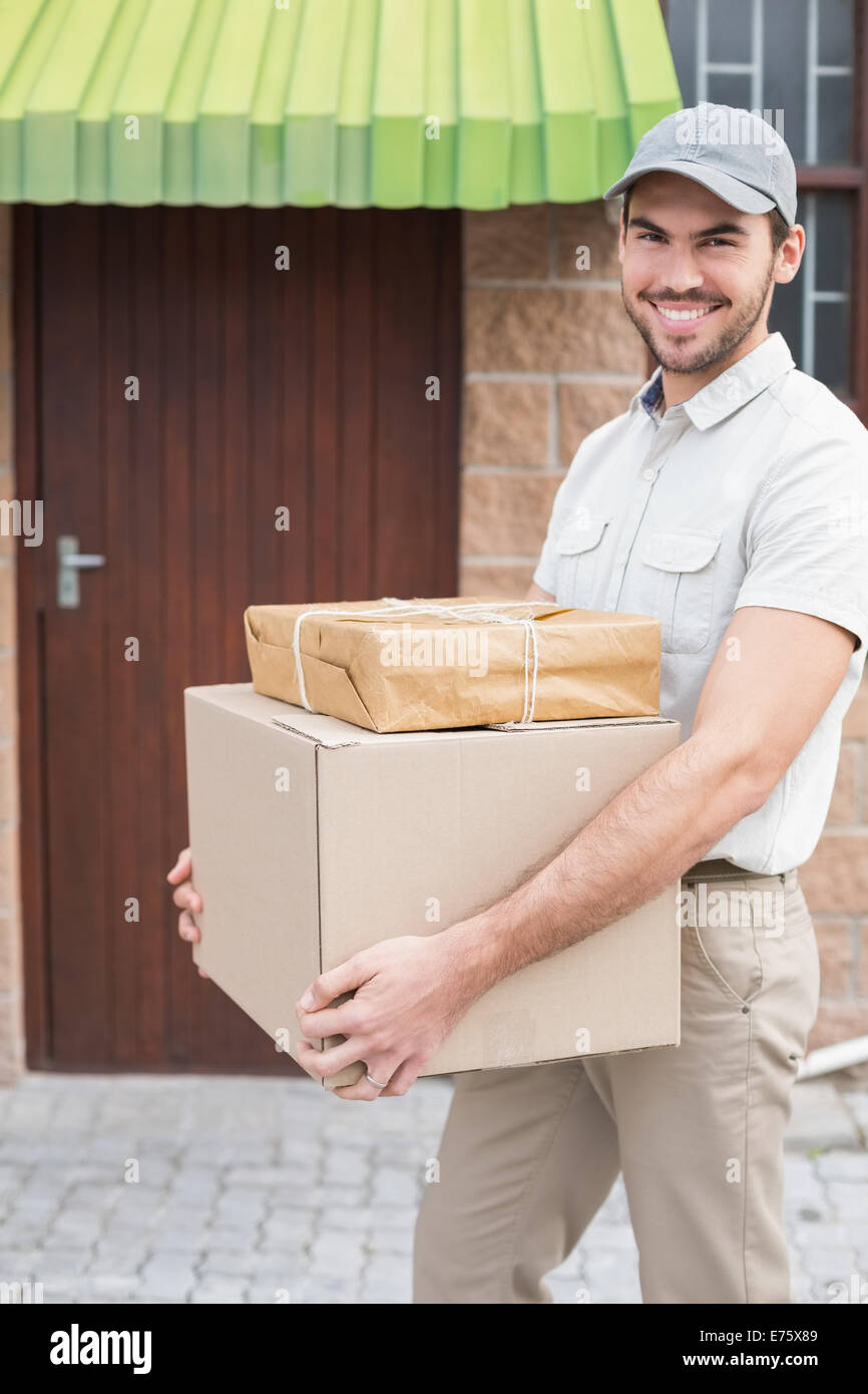 Delivery driver walking with parcels Stock Photo - Alamy