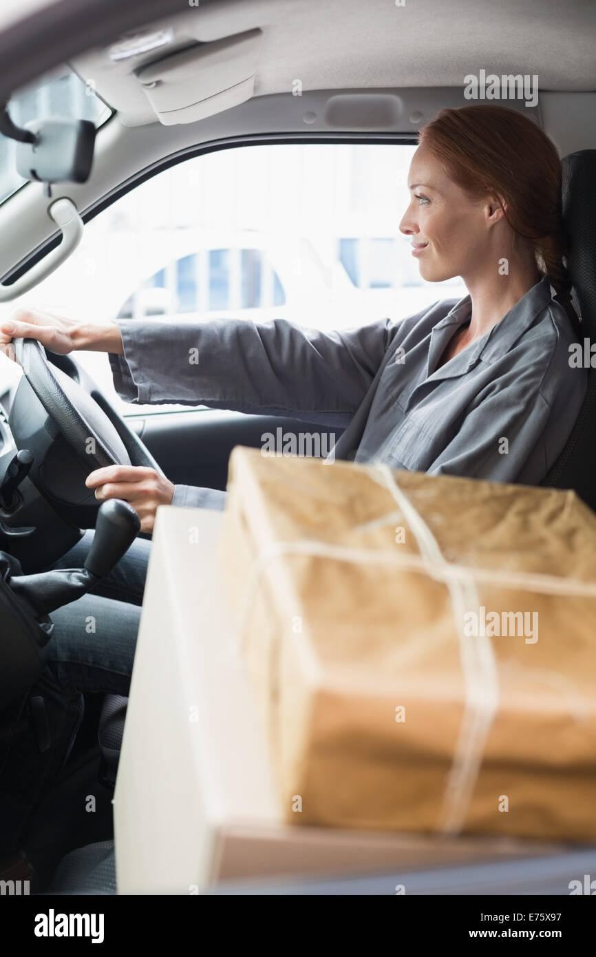 Delivery driver driving van with parcels on seat Stock Photo - Alamy