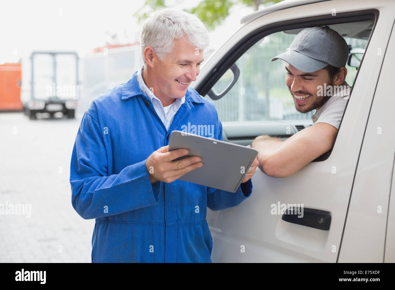 Delivery driver smiling at camera with customer Stock Photo - Alamy