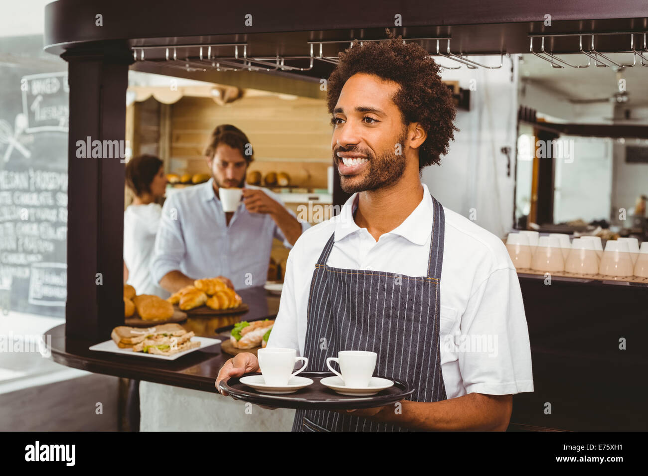 Handsome waiter smiling and holding tray Stock Photo - Alamy