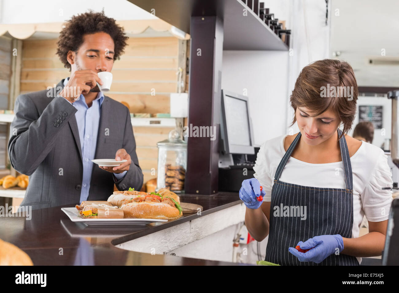 Happy server preparing food at counter Stock Photo - Alamy