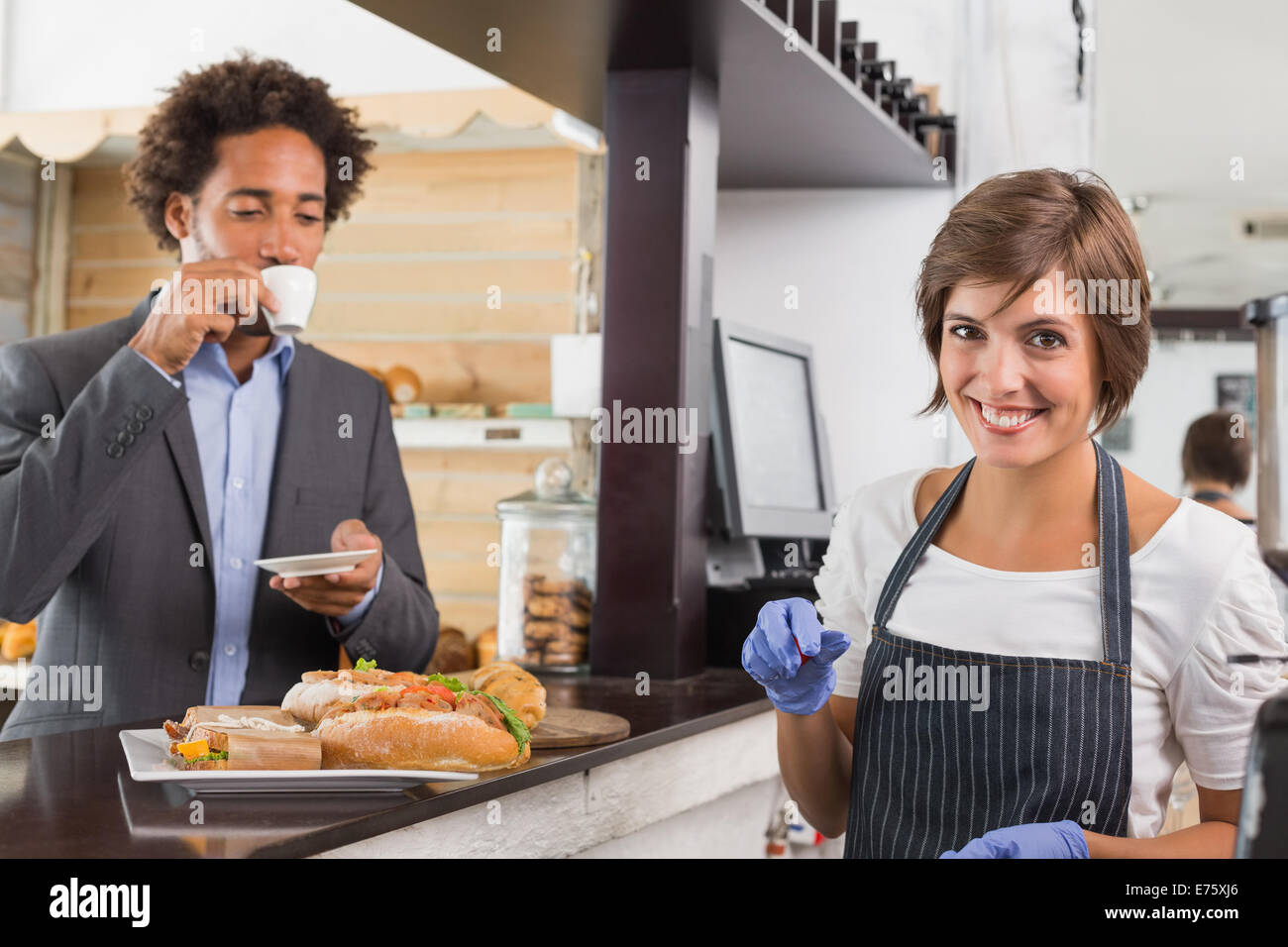 Happy server preparing food at counter Stock Photo - Alamy