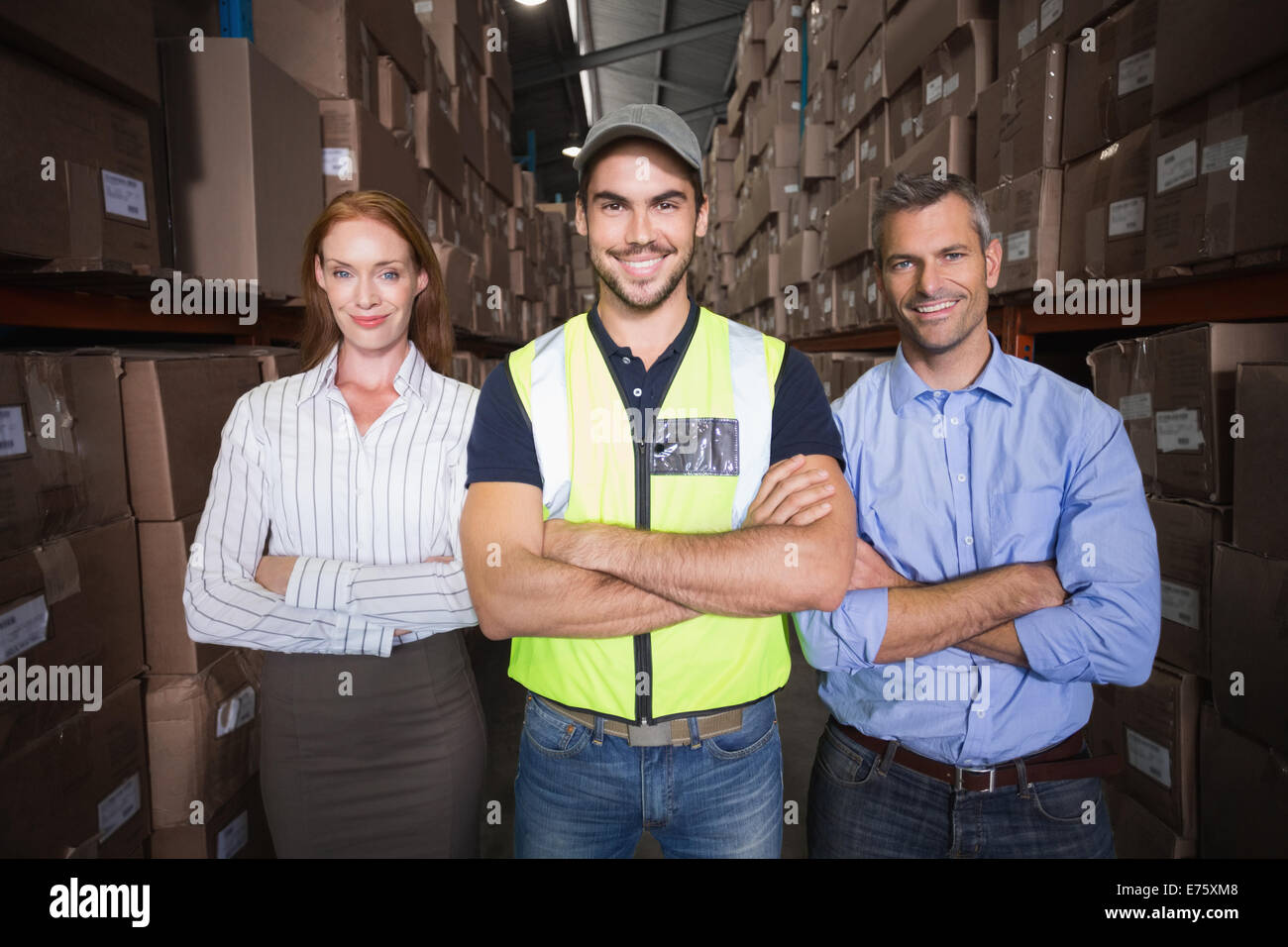 Warehouse team smiling at camera showing thumbs up Stock Photo - Alamy