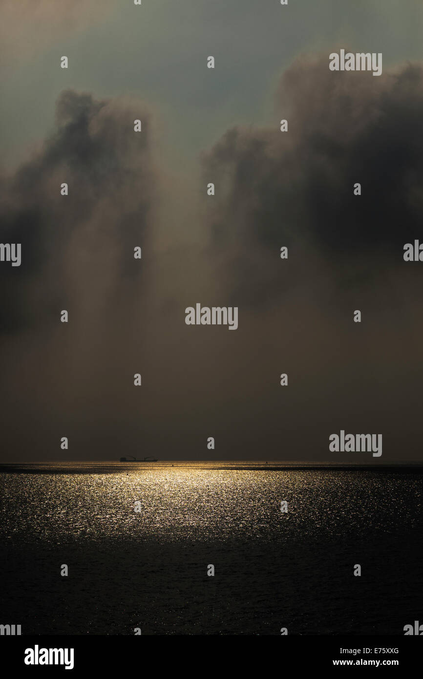 Sun Breaking Through Clouds to Illuminate Sea Stock Photo - Alamy