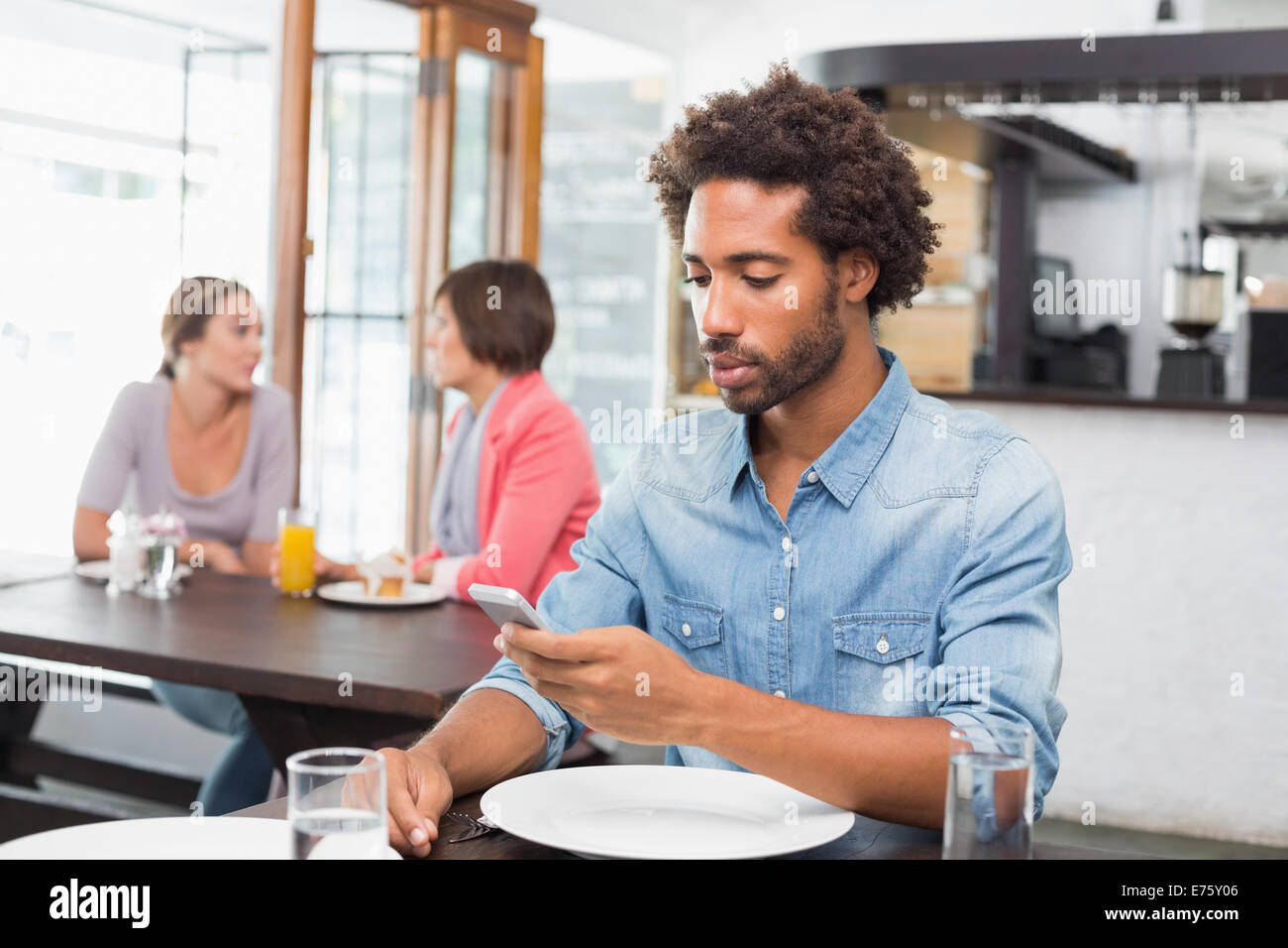 Handsome man sending a text Stock Photo - Alamy