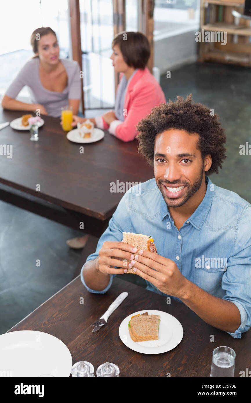 Handsome man eating a sandwich Stock Photo - Alamy