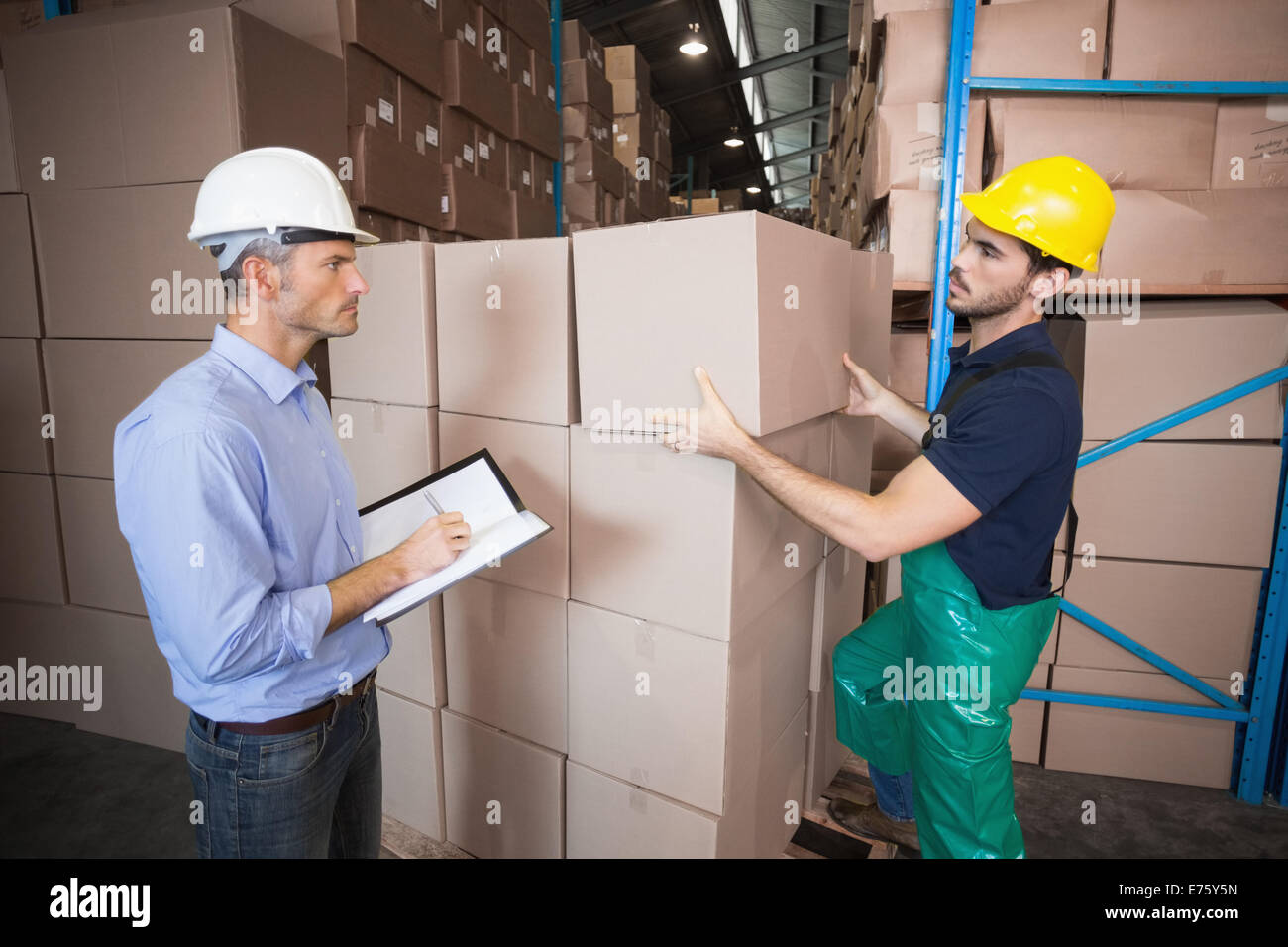 Warehouse worker loading up a pallet with manager Stock Photo - Alamy