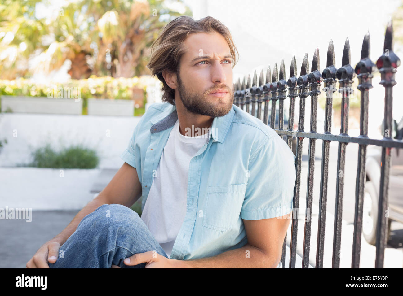 Casual man sitting and thinking Stock Photo - Alamy