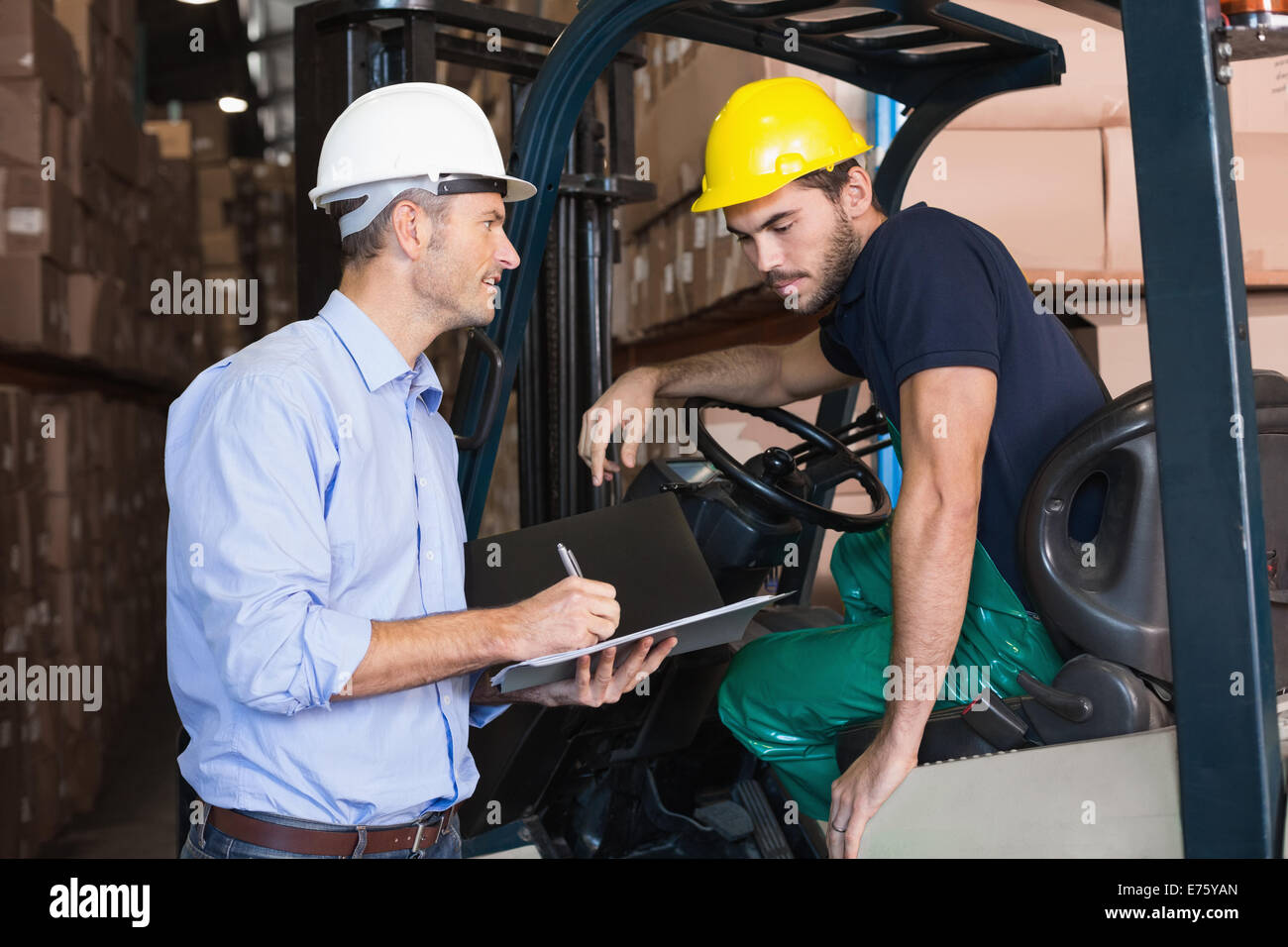 Warehouse workers interacting forklift driver hi-res stock photography ...