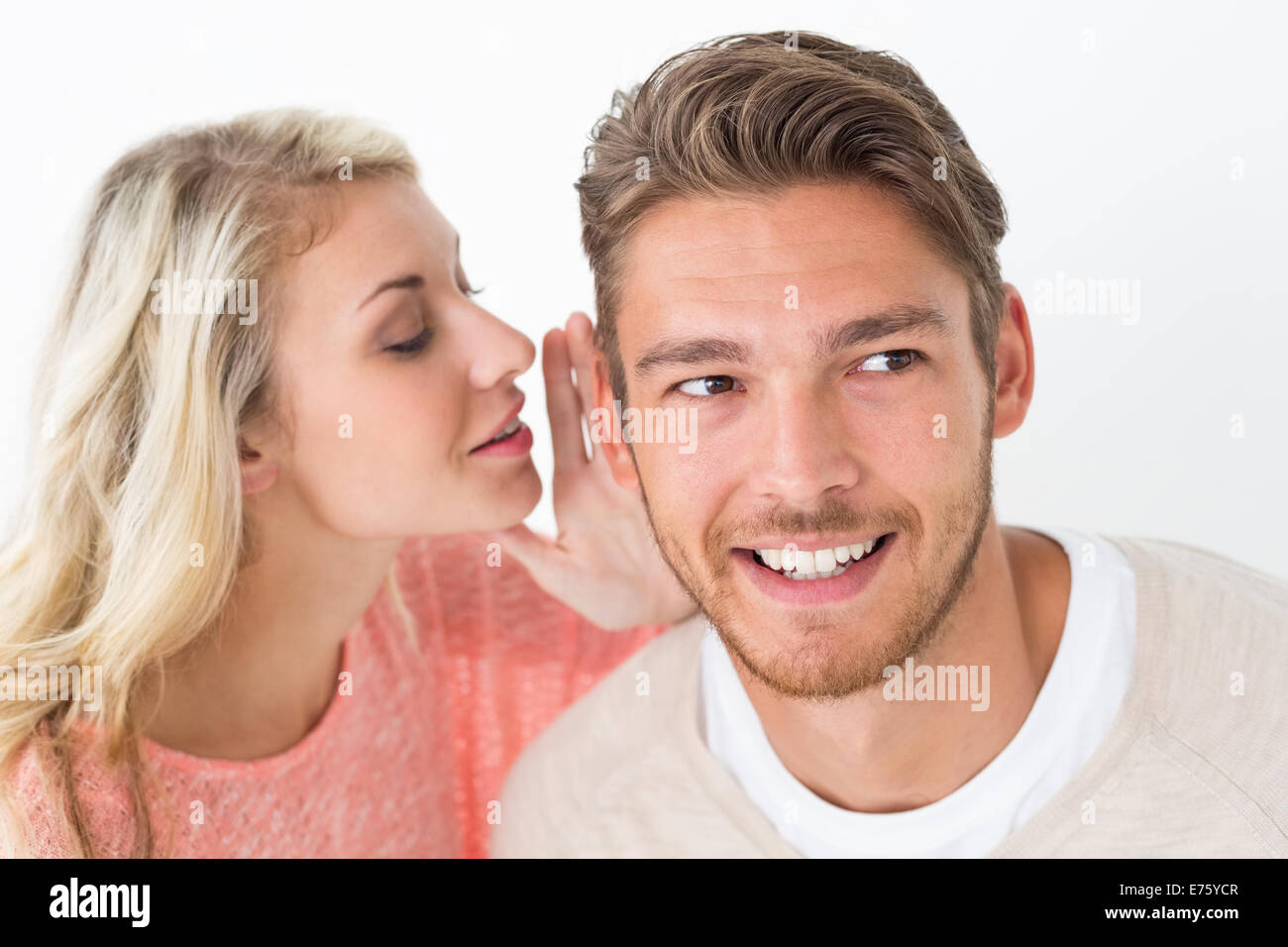 Woman whispering secret into a man's ear Stock Photo - Alamy