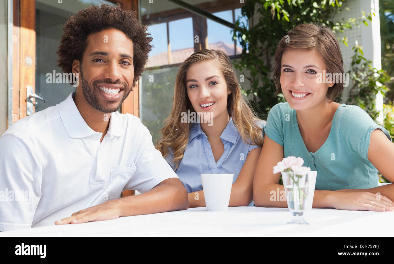 Happy friends smiling at camera in cafe Stock Photo - Alamy