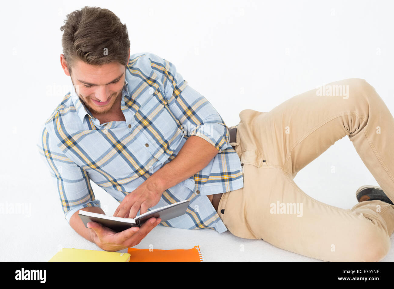 Relaxed young man reading book Stock Photo - Alamy