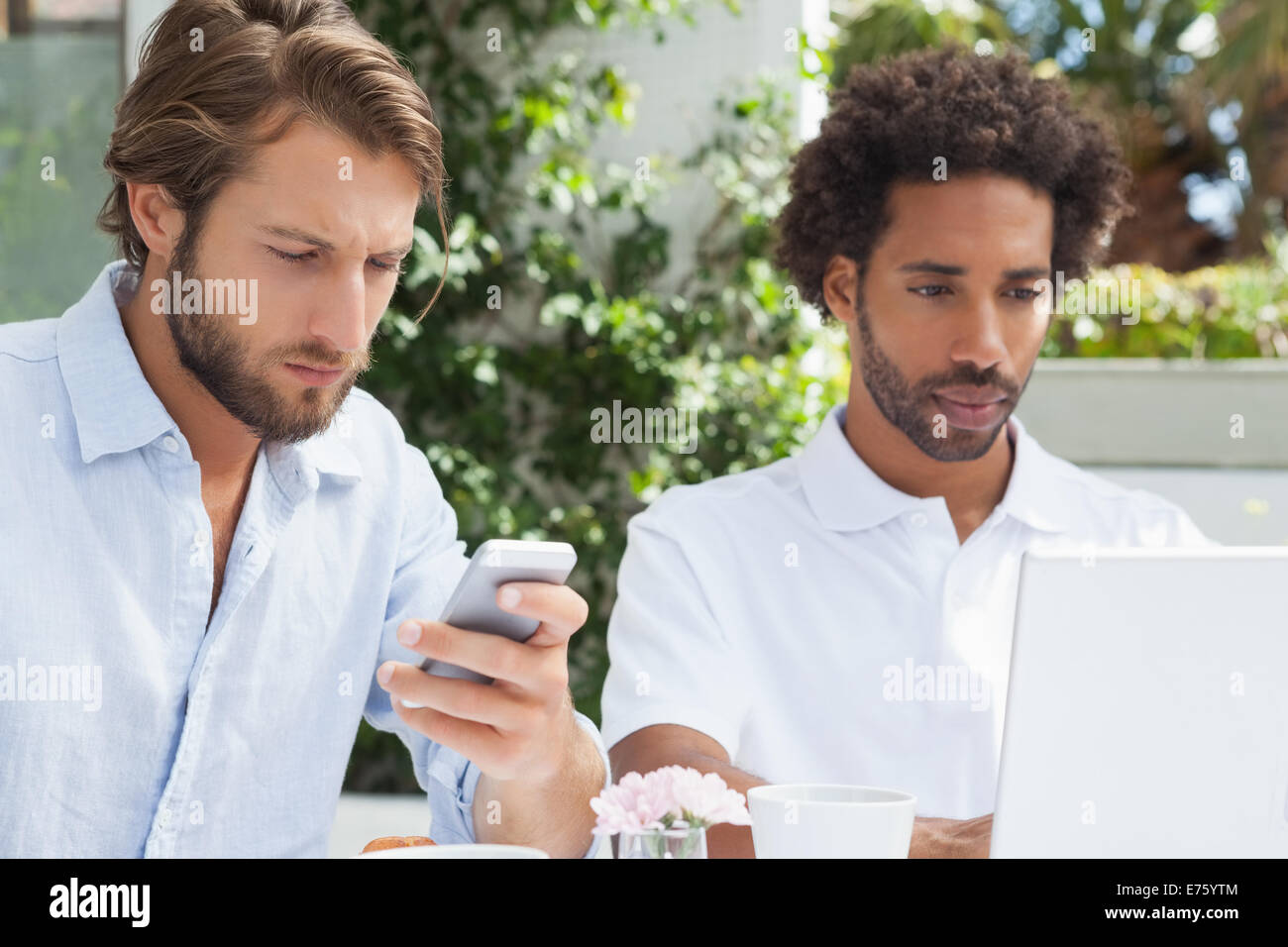 Two busy friends having coffee together Stock Photo - Alamy