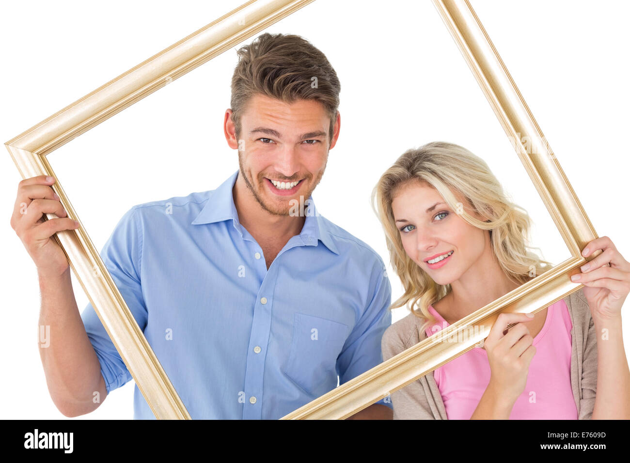 Attractive couple smiling at camera through picture frame Stock Photo ...