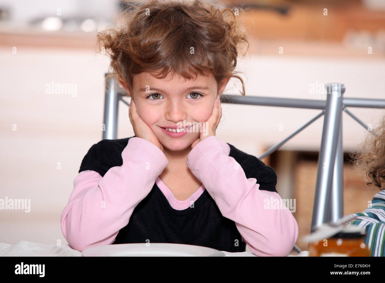 Girl sitting at table Stock Photo - Alamy