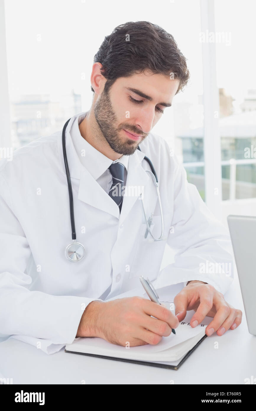 Doctor sitting and taking notes Stock Photo - Alamy