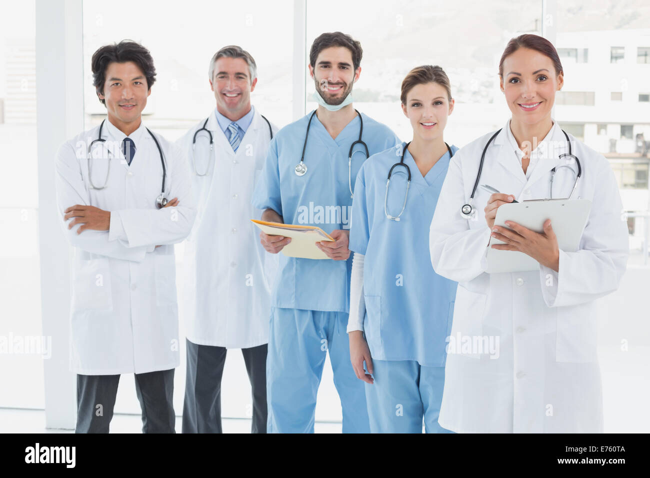 Smiling doctors all standing together Stock Photo - Alamy
