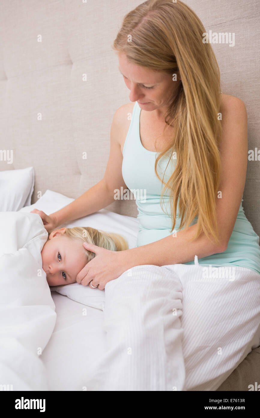 Mother tucking child into bed hi-res stock photography and images - Alamy