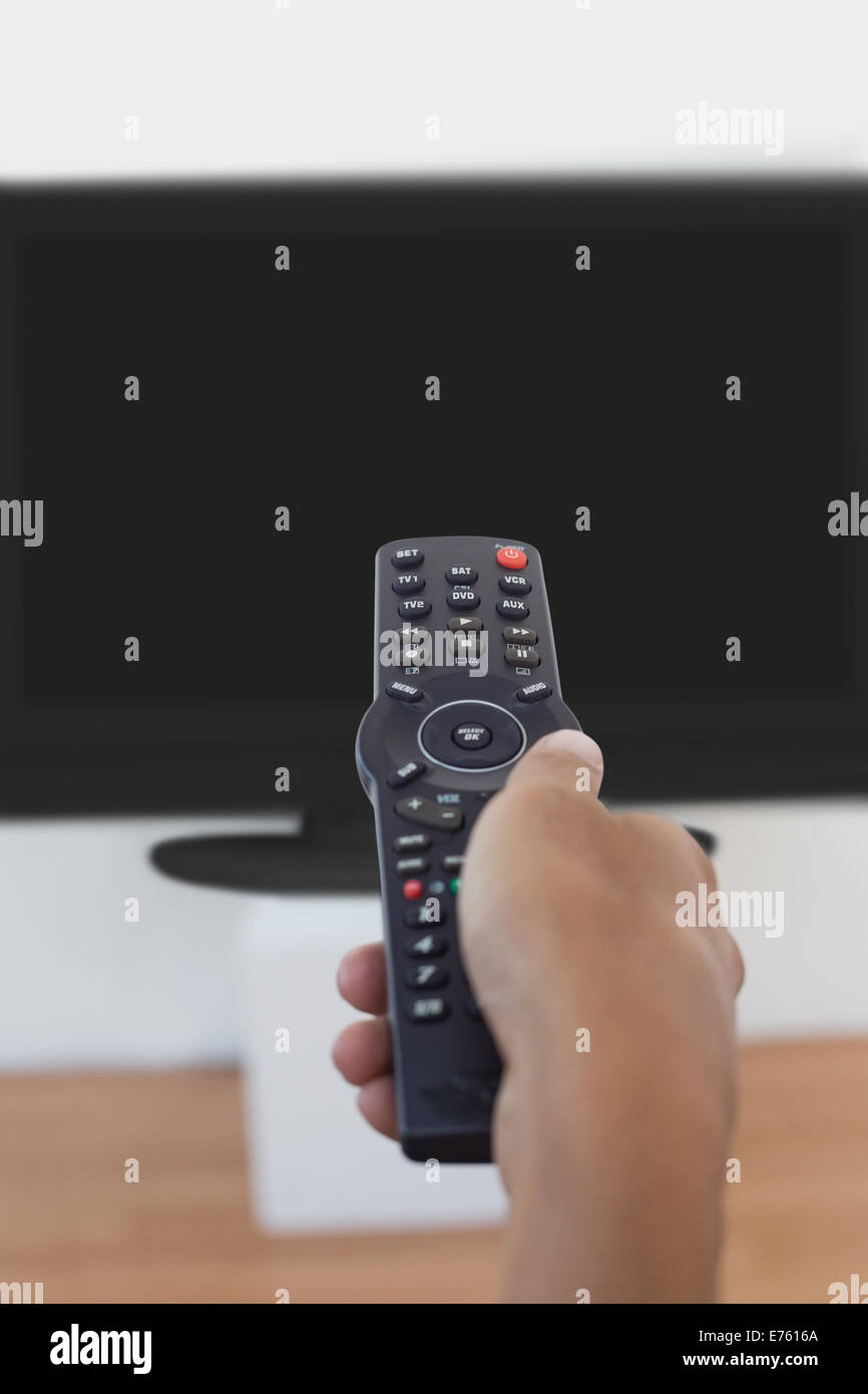 Hand holding remote and changing channel Stock Photo - Alamy