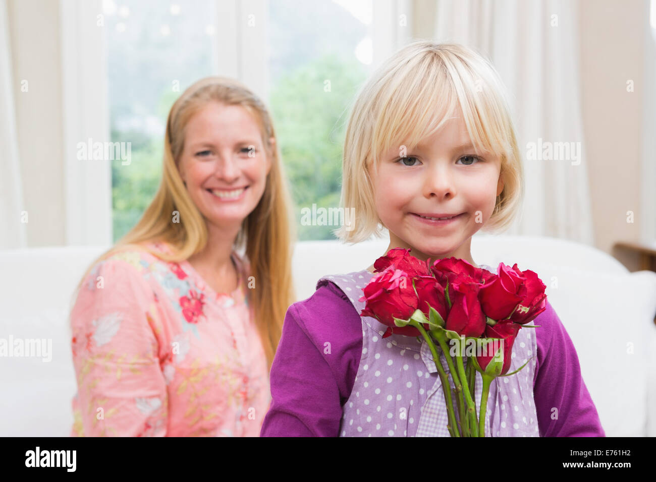 Happy woman holding red roses with daughter Stock Photo - Alamy