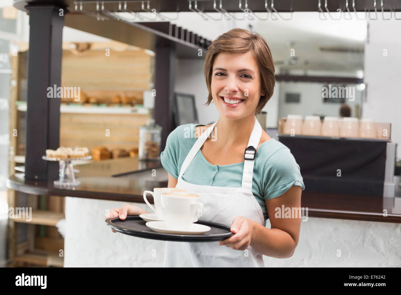 Waitress holding tray with cappuccinos Stock Photo - Alamy