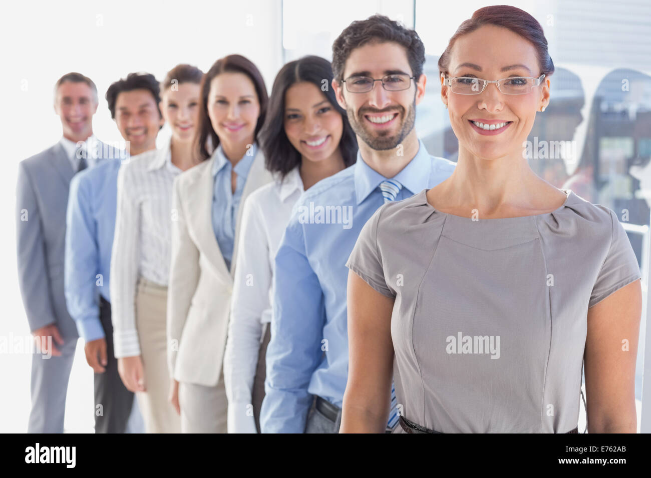 Smiling workers in a line Stock Photo - Alamy