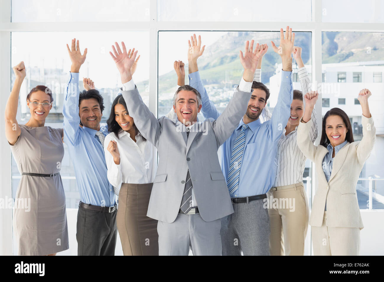 Cheering workers with raised arms Stock Photo - Alamy