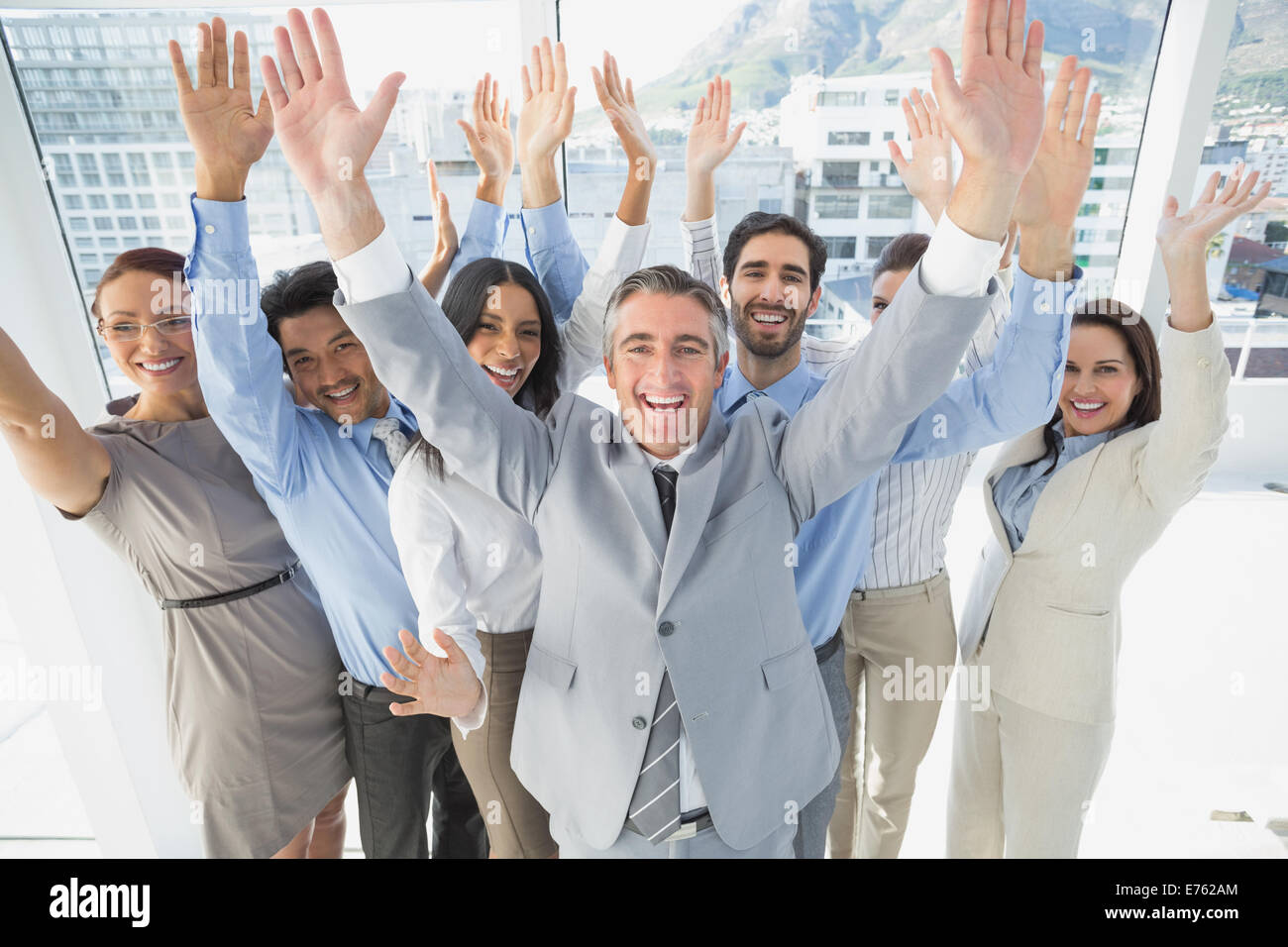 Cheering workers with raised arms Stock Photo - Alamy