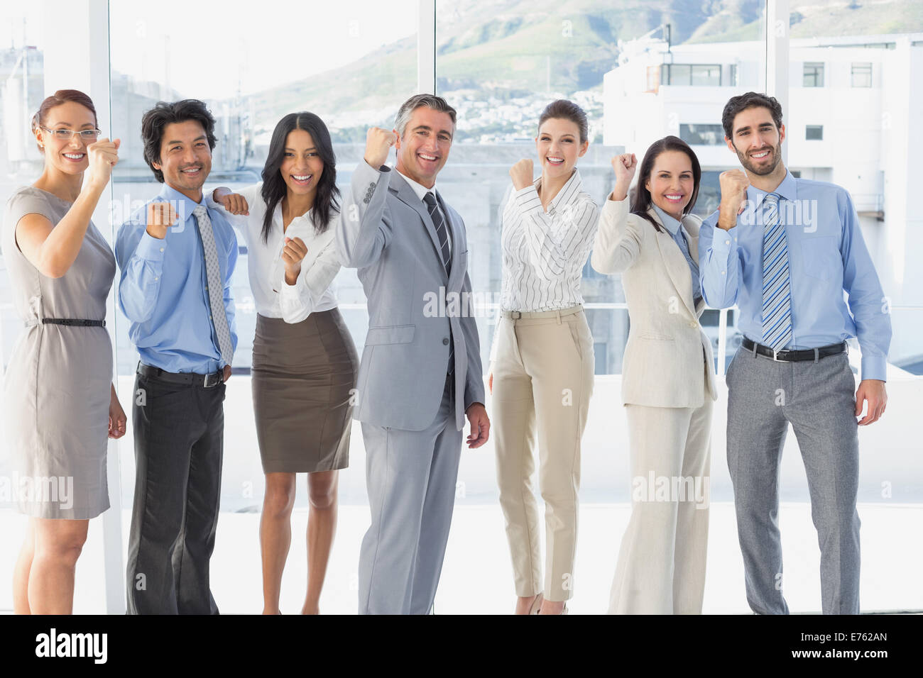 Cheering workers with raised arms Stock Photo - Alamy