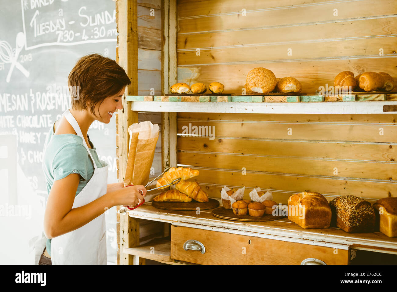 Pretty waitress picking up croissant Stock Photo - Alamy