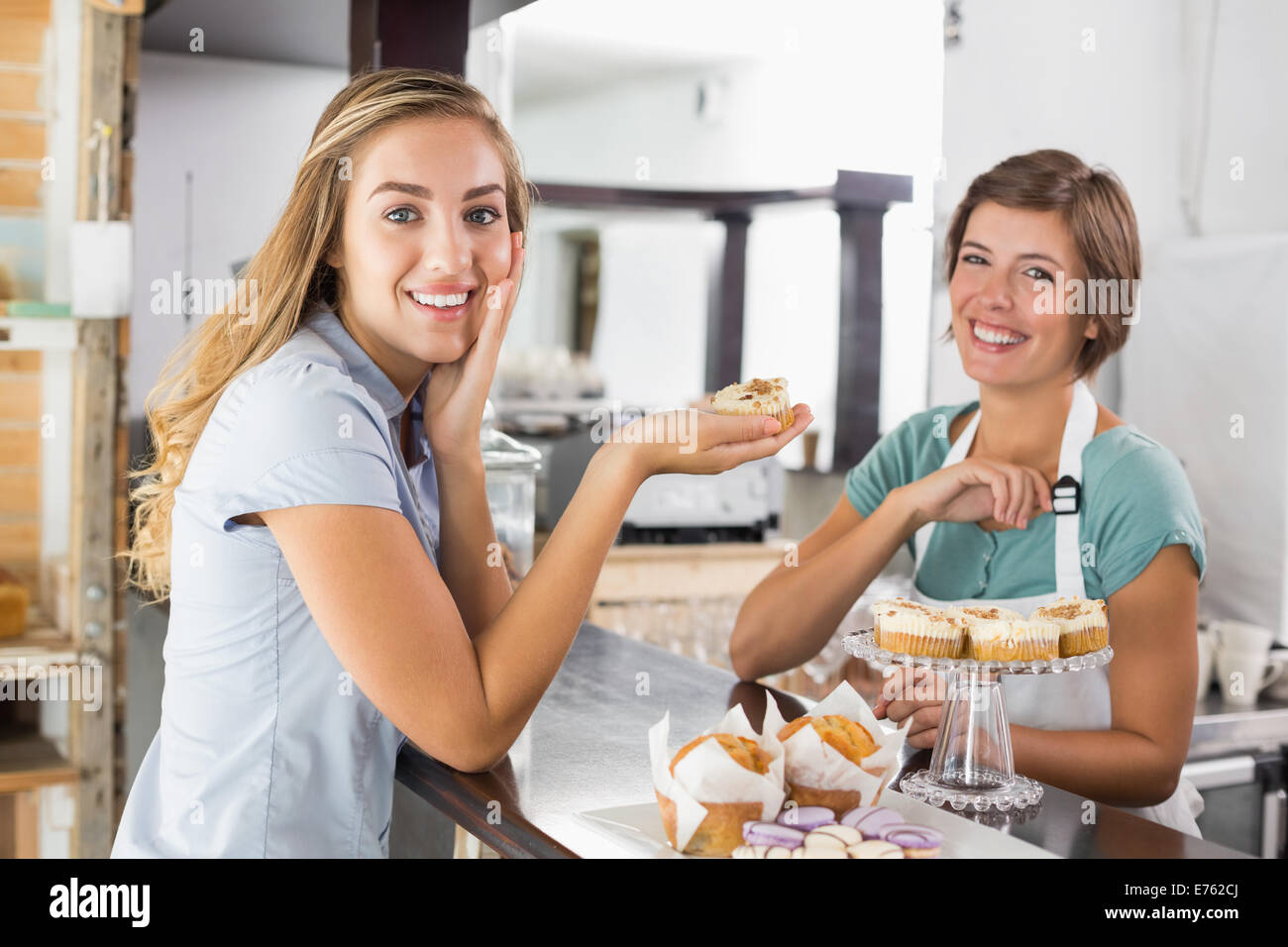 Pretty waitress serving cupcake to customer Stock Photo - Alamy