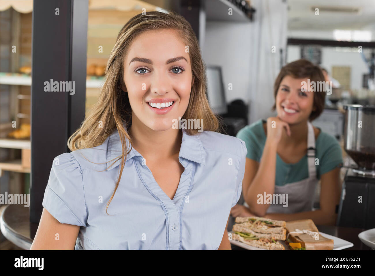 Pretty waitress and customer smiling at camera Stock Photo - Alamy