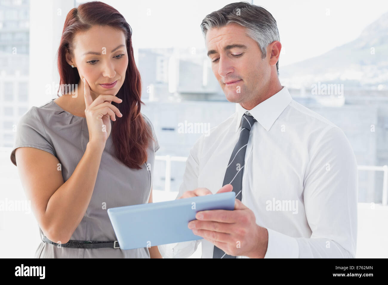 Business people comparing work notes Stock Photo - Alamy