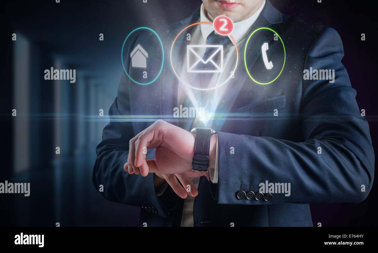 Composite image of businessman using hologram watch Stock Photo - Alamy