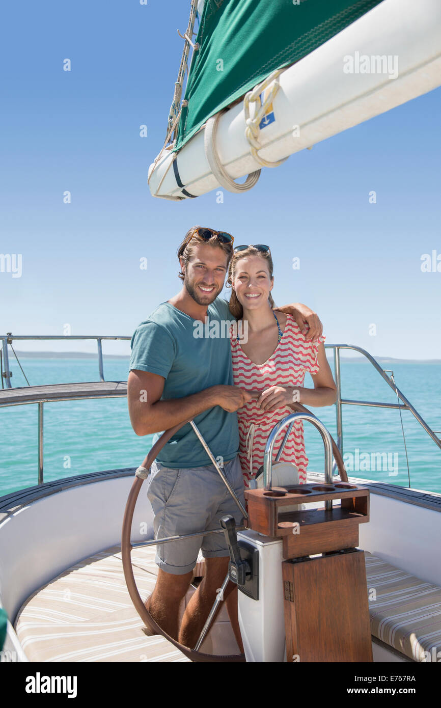 Couple steering sailboat together Stock Photo - Alamy