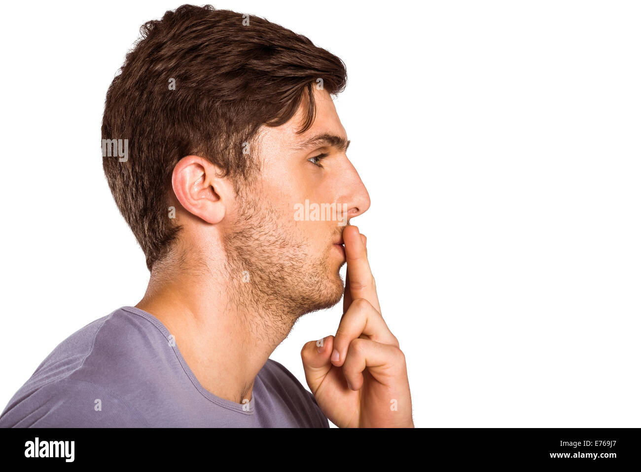 Young man with finger on lips Stock Photo - Alamy