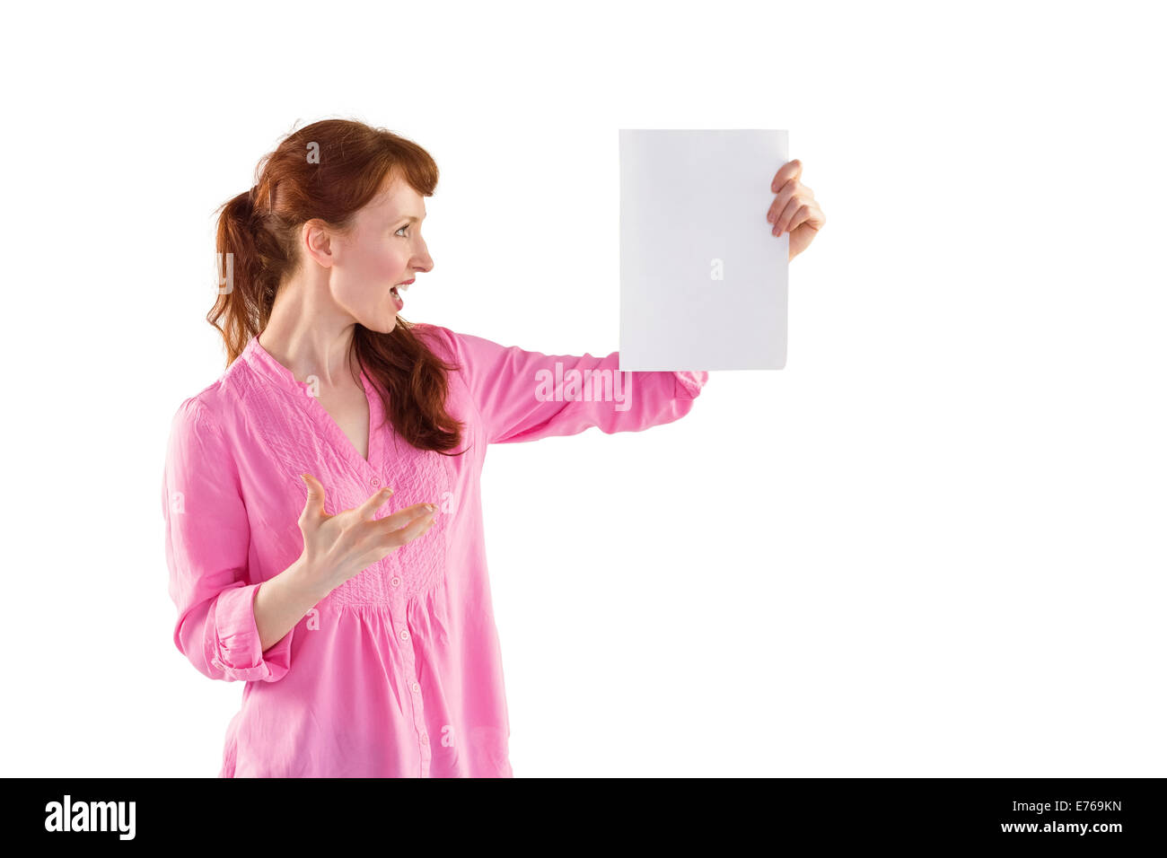 Woman shocked looking at paper Stock Photo - Alamy