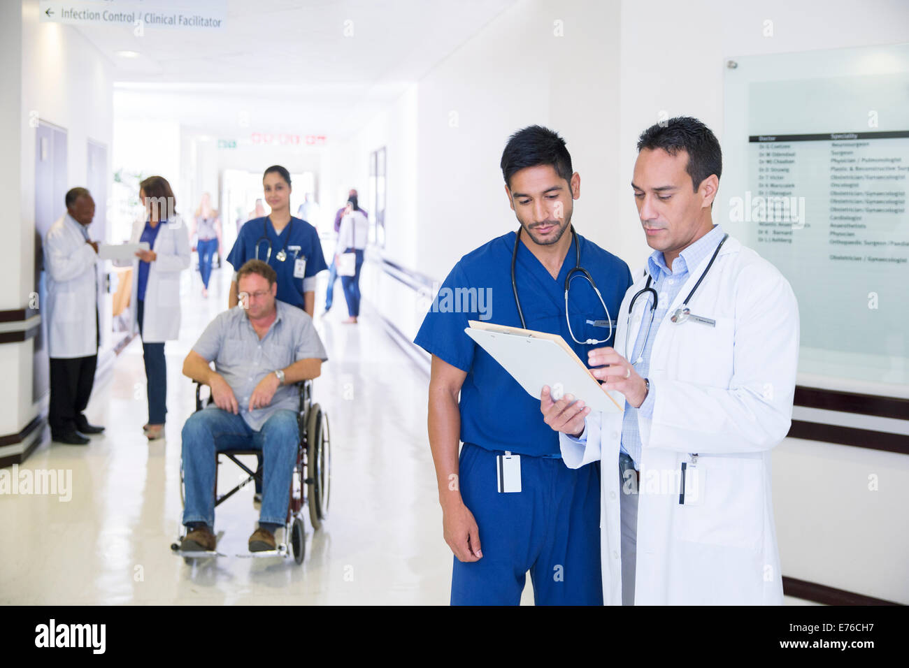 Doctor and nurse reading medical chart in hospital hallway Stock Photo ...