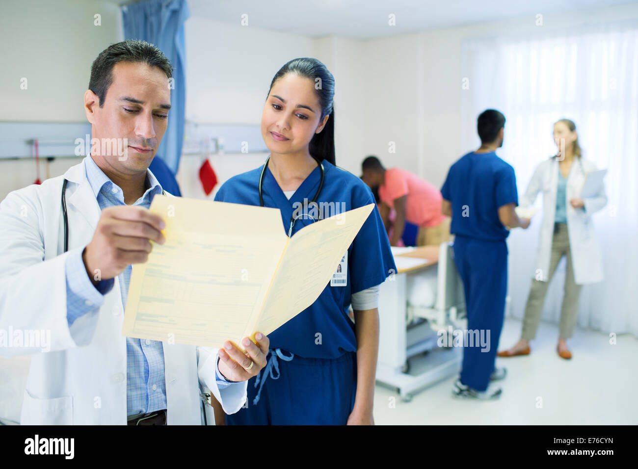 Doctor and nurse reading medical chart in hospital room Stock Photo - Alamy