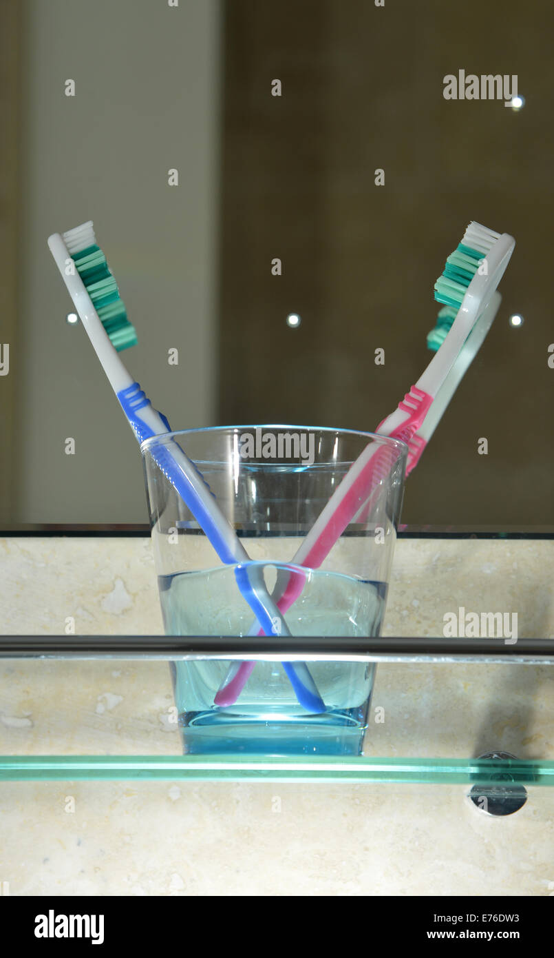Pink and blue toothbrushes facing each other Stock Photo - Alamy