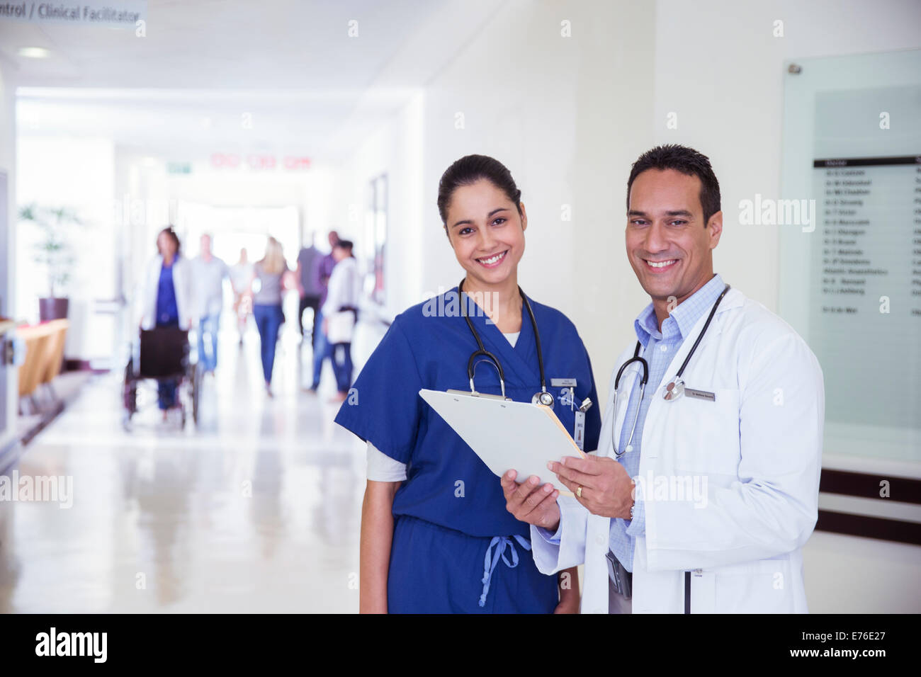 Doctor and nurse reading medical chart in hospital hallway Stock Photo ...